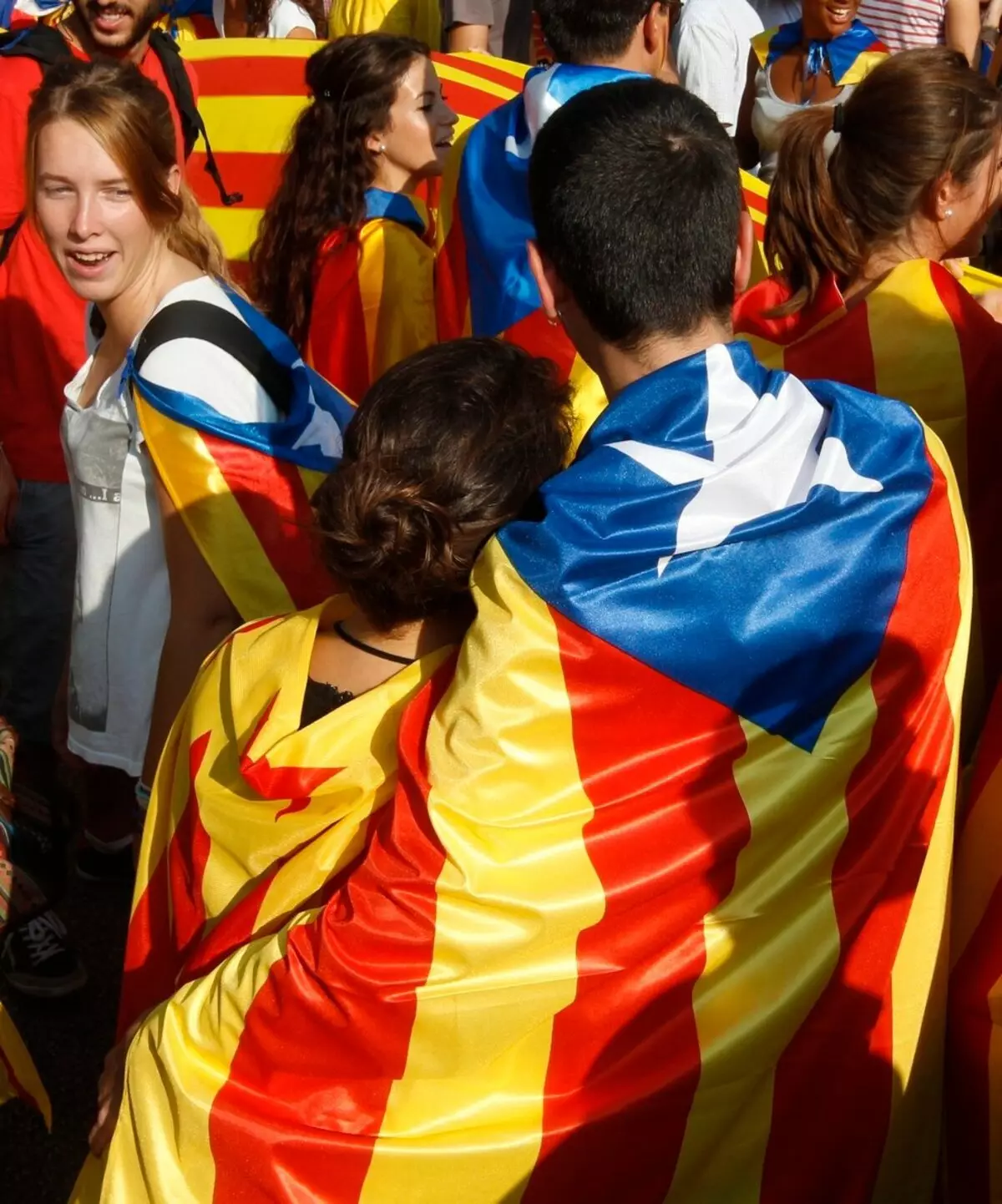 A couple wrapped in a Catalonian nationalist flag take part in a demonstration during Catalan National Day in Barcelona