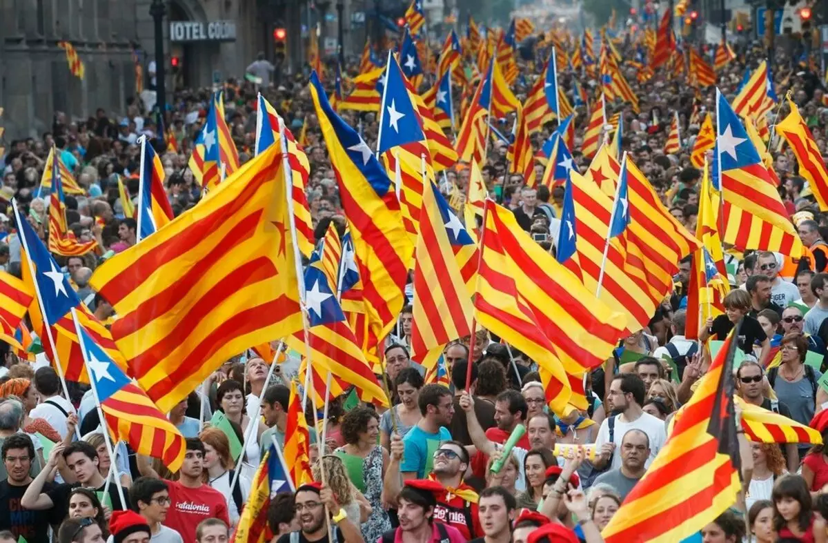 Marchers Wave Catalonian Nacionalistické vlajky ako demonštračné počas katalánskeho národného dňa v Barcelone